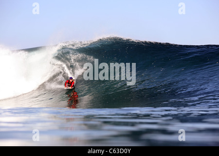 Surfer riding a large wave at Scar reef in West Sumbawa, Indonesia ...