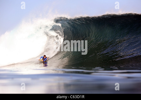 Surfer riding a large wave at Scar reef in West Sumbawa, Indonesia ...