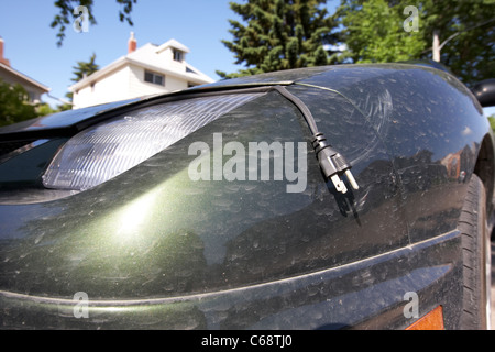 engine block heater cord and plug hanging out of a car for cold winter ...
