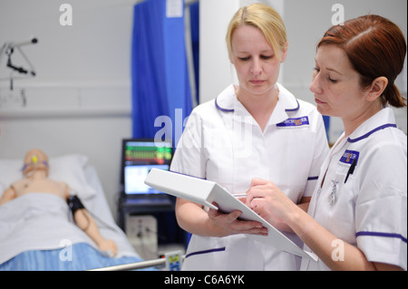student nursing nurses reading patient chart by human anatomy model in ...