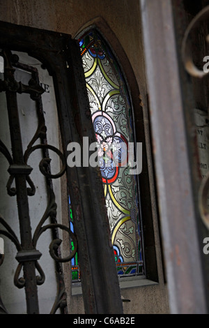 Stained glass window on a grave or mausoleum in the graveyard at the ...
