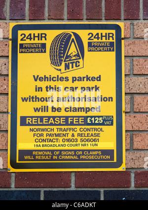 Wheel clamping sign in car park in UK Stock Photo - Alamy