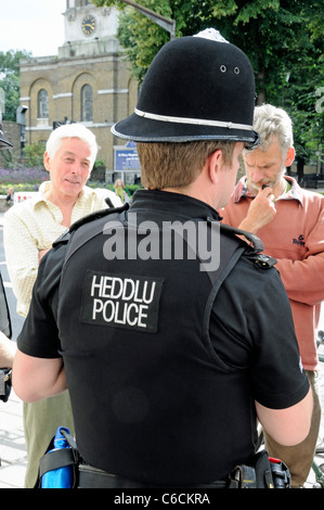 Rear view of a British Police officer wearing a bullet proof vest ...