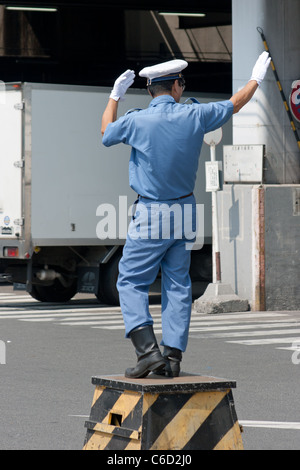 An Asian male traffic cop directing traffic on Cana Street in Chinatown ...