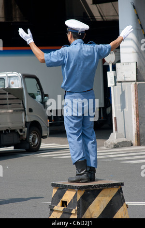 An Asian male traffic cop directing traffic on Cana Street in Chinatown ...