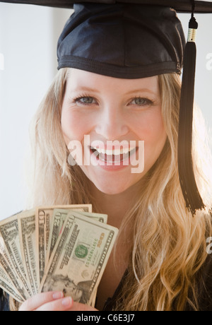 Young caucasian woman wearing graduation ceremony robe sitting on the ...