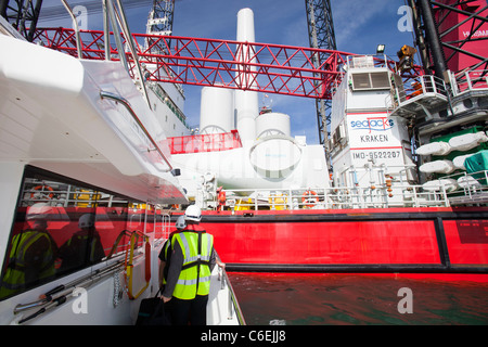 Offshore wind farm, crew transfer vessel docked on landing station ...