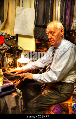 Tailor stitching a suit at work on his singer sewing machine old man ...