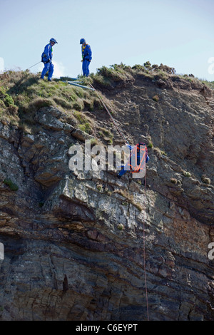 Coastguards abseiling rescuing injured walker on cliff in Pembrokeshire ...