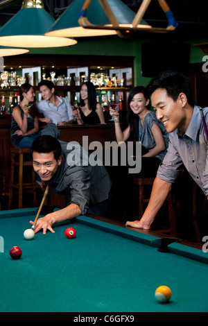 Chinese friends playing pool at a bar Stock Photo - Alamy