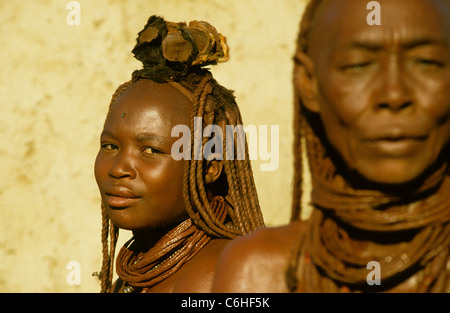 Pretty young Himba woman in the dark in front of her mud hut at the ...