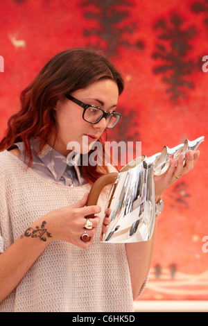 Dealer Emily Wynne-Jones examines a silver water jug by De Vecchi at ...