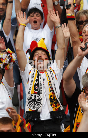 German spectators in stadium cheering their national team. People from ...
