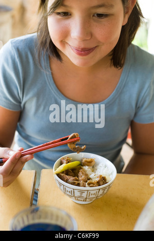 Girl eating rice with chop sticks Stock Photo - Alamy