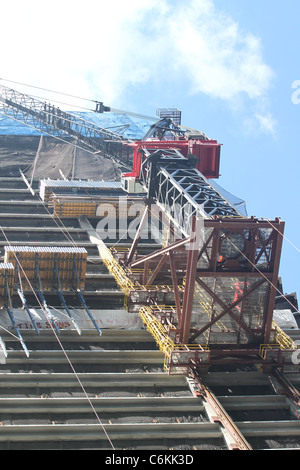 Construction crane attached to a high-rise building. Skyscraper ...