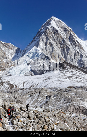 The domed Pumori mountain with the black rock of Kala Pathar in front ...