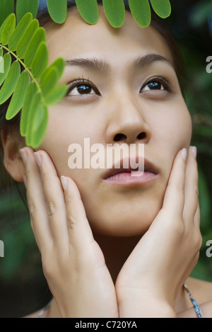 cropped shot, Young Asian woman holding pen and using her smartphone at ...