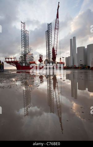 A jack up barge being loaded with wind turbine parts at night, for the ...
