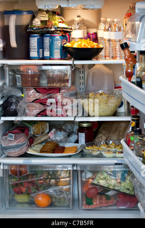Open refrigerator with stocked food products in commercial kitchen ...