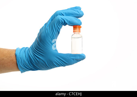 A gloved hand holding a vial / bottle of AstraZeneca covid-19 vaccine ...