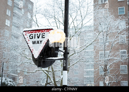 A road sign covered in snow warning car drivers of hazardous driving ...