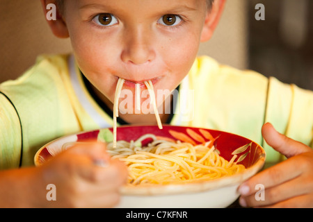 Boy slurping spaghetti at table Stock Photo - Alamy