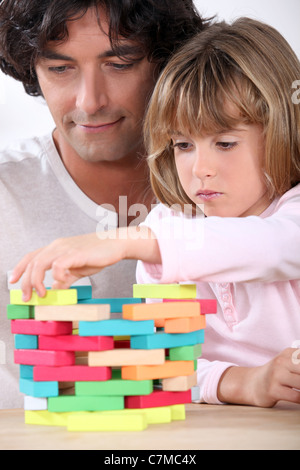 Father and child bonding while building a tower with toy blocks on the ...
