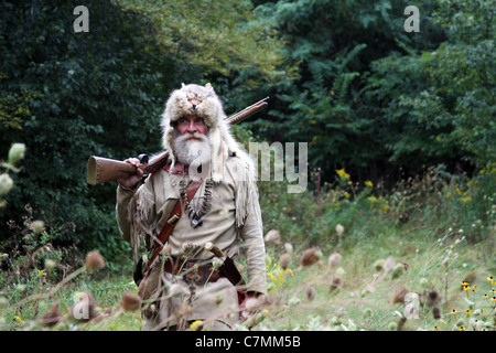 A hunter with a fox fur hat hunting in the woods Stock Photo - Alamy