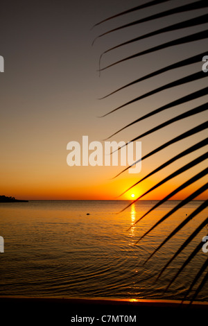 Beautiful orange sunset behind silhouette of low mountains and blue ...