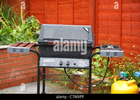 wet gas bbq soaked in heavy rainfall in a garden in the uk Stock Photo ...