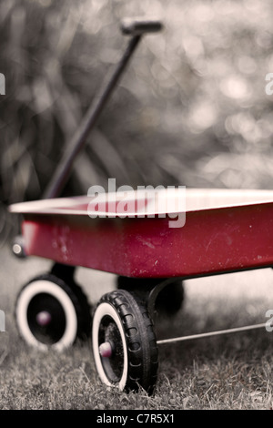 A childs red pull cart trolley for playing in the garden and collecting ...