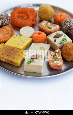 traditional indian candy soan papdi in a blue ceramic plate with almond ...