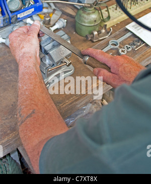 Engineer filing a washer held in a mini vice Stock Photo - Alamy
