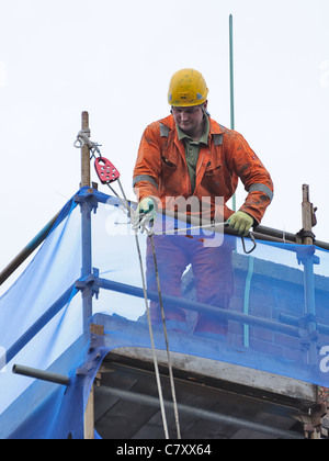 Scaffolding. Building scaffold with a platform and netting, England, UK ...