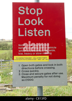 Railroad crossing stop look and listen sign white with black letters ...