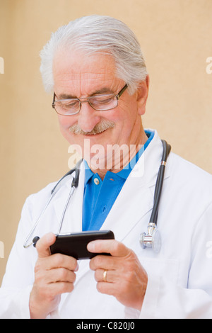 Studio shot of senior man doctor reading on clipboard Stock Photo - Alamy