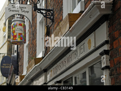 Hanging shop sign advertising a sweet shop down the old narrow lanes of ...