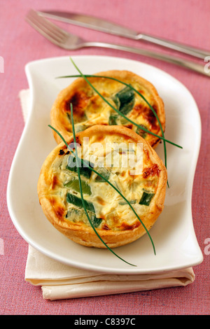 Homemade leek quiche with a baked cheese crust in a glass dish, cooling ...