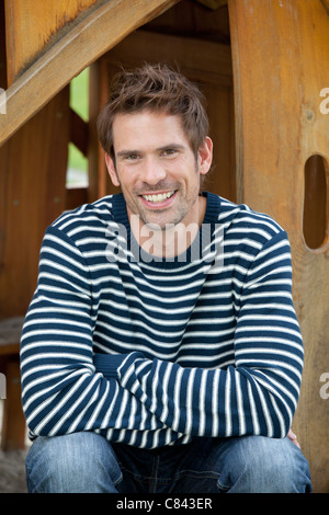 Image of brunette man in striped t-shirt smiling while holding credit ...