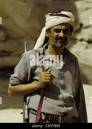Arab man with beard standing over bricks wall background with hand on ...