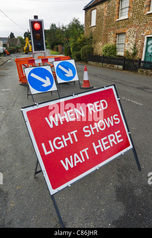 when red light shows wait here stop signs next to portable traffic ...