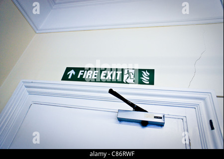 fire exit sign above green wooden door Stock Photo - Alamy