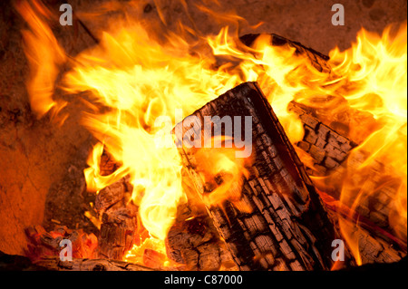 Close up of burning firewood with bright orange flames and smoke ...