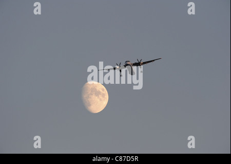 An aeroplane flies past the moon Stock Photo - Alamy