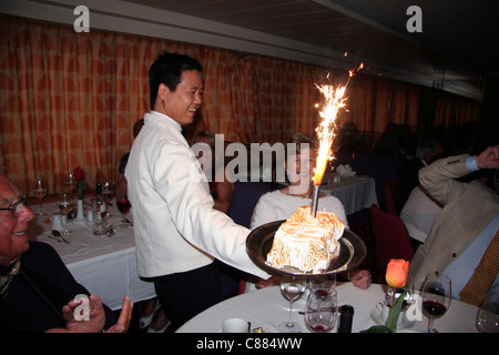Waiter with baked alaska and sparkler, Captain's dinner, aboard a ...