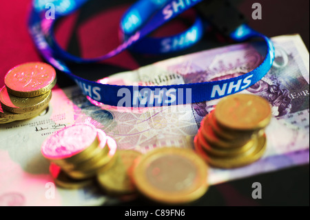 NHS staff neck chain laying on twenty pound notes magnified with pound ...