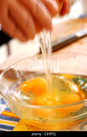 breaking an egg into a glass bowl Stock Photo - Alamy