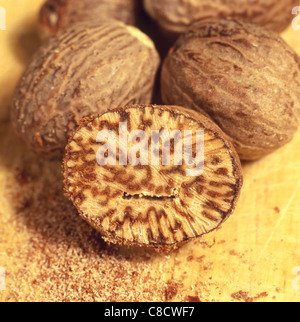 Nutmeg , whole and half on wooden plank, close up Stock Photo - Alamy
