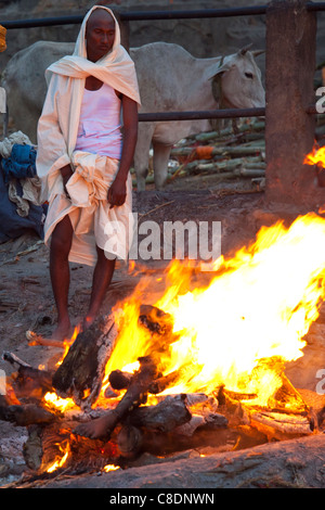 A body is burning on a funeral pyre on a ghat along the Ganges river in ...