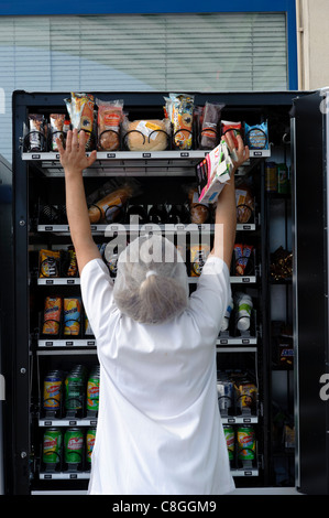 Woman restocking vending machine Stock Photo - Alamy